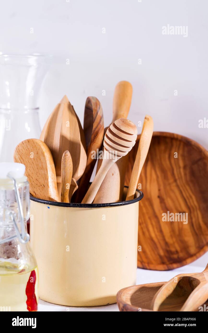 Wooden set of kitchenware in iron cup with wooden plates on white ...
