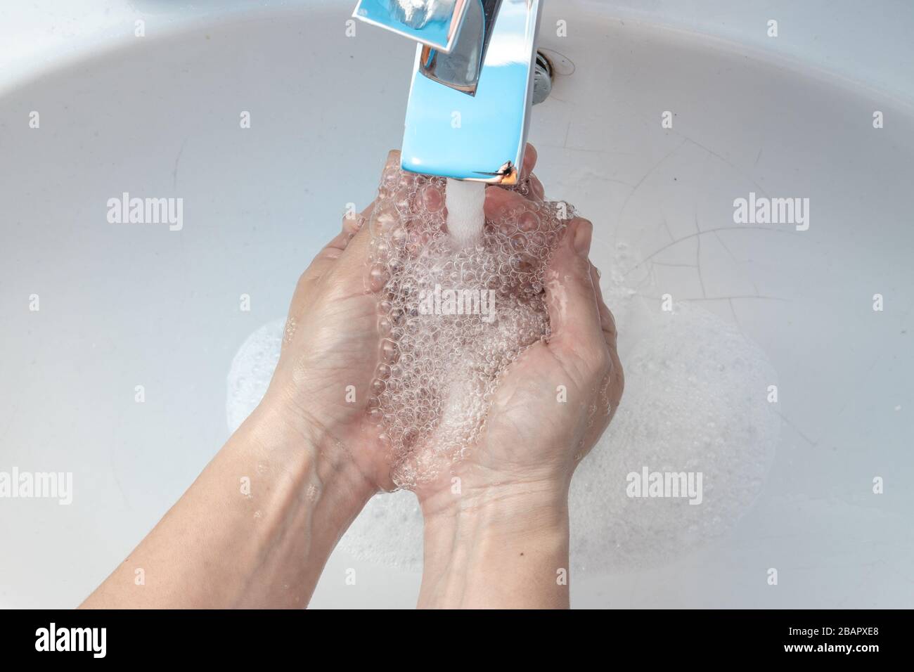 Top above close up view woman standing in bathroom washing her hands ...