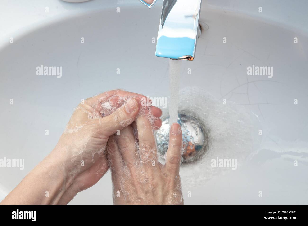 Top above close up view woman standing in bathroom washing her hands ...