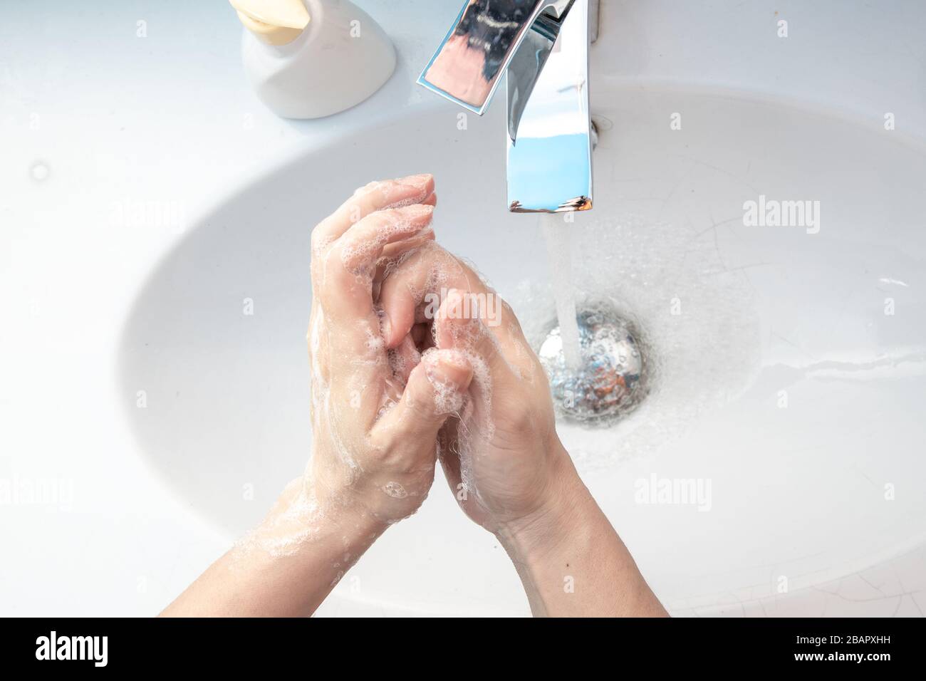 Top above close up view woman standing in bathroom washing her hands ...