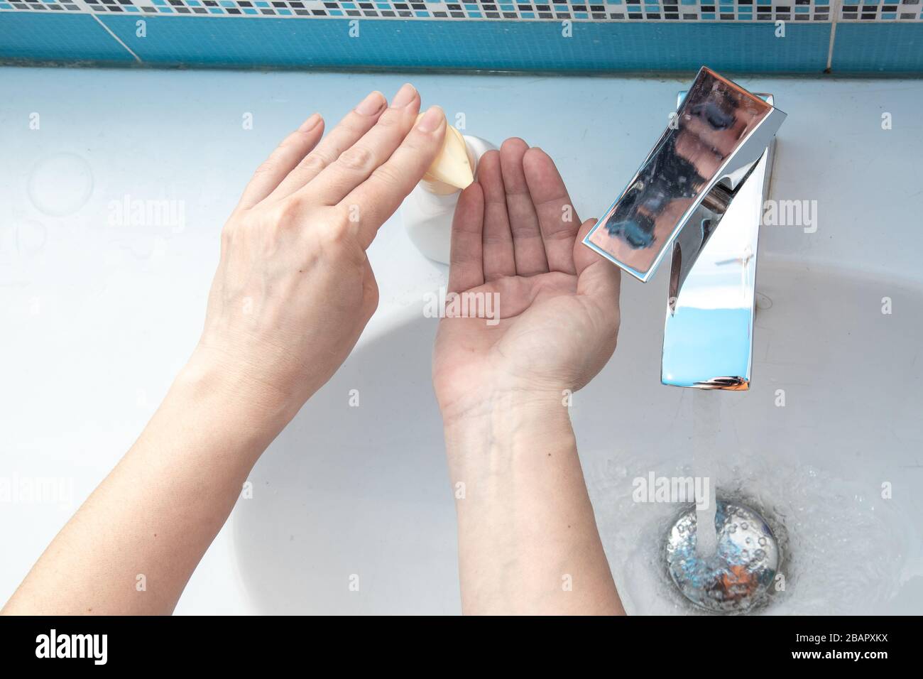 Top above close up view woman standing in bathroom washing her hands ...