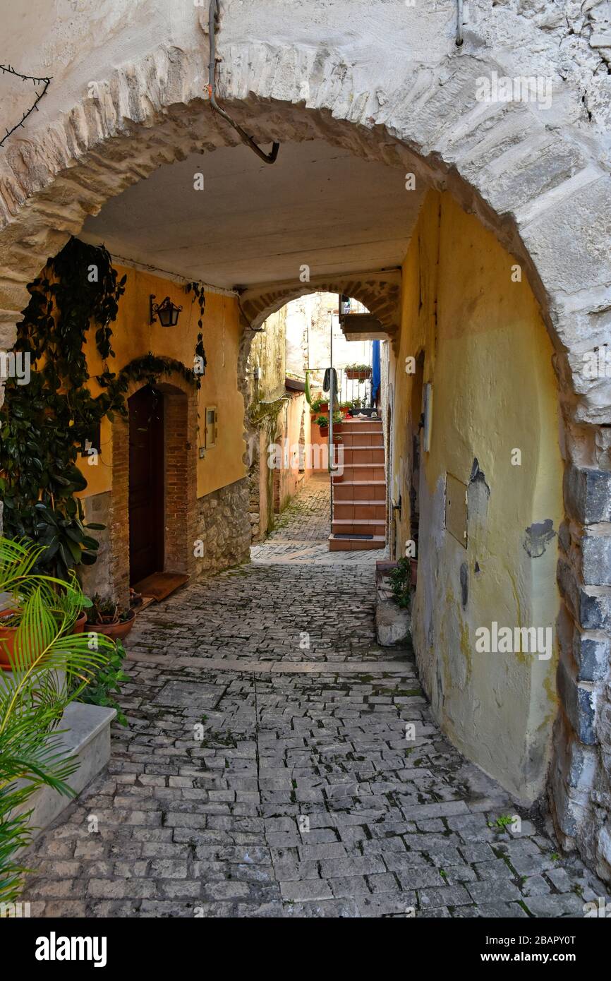 A narrow street between the stone houses of Maranola, a medieval ...