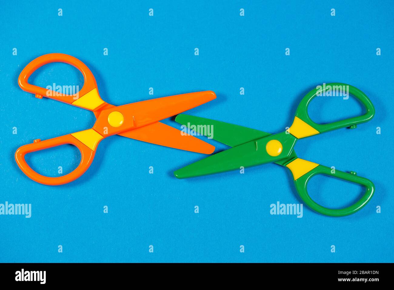 Children's plastic scissors for cutting paper figures on a colored ...