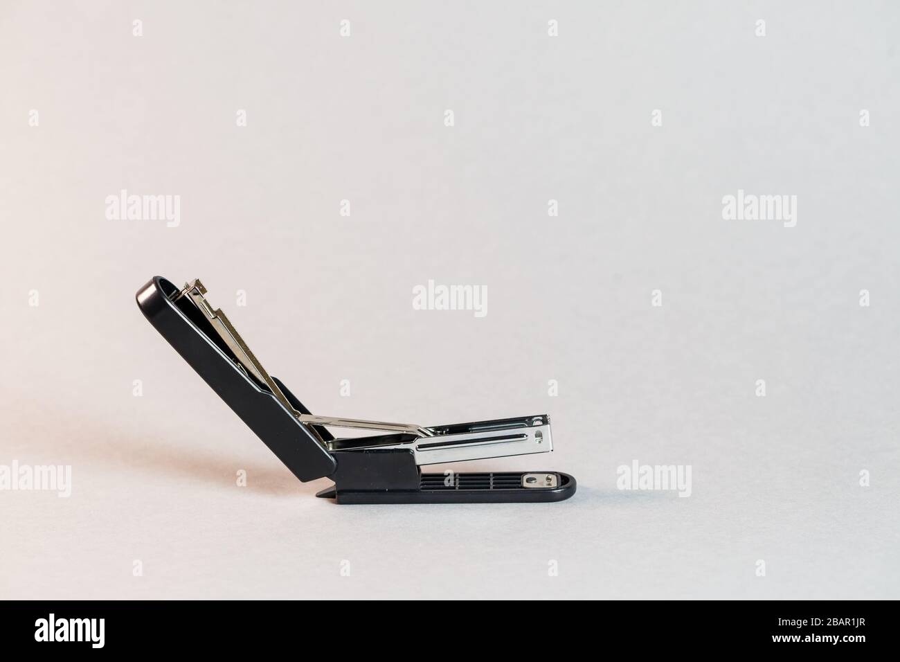 black stapler for fastening papers on a gray background Stock Photo - Alamy
