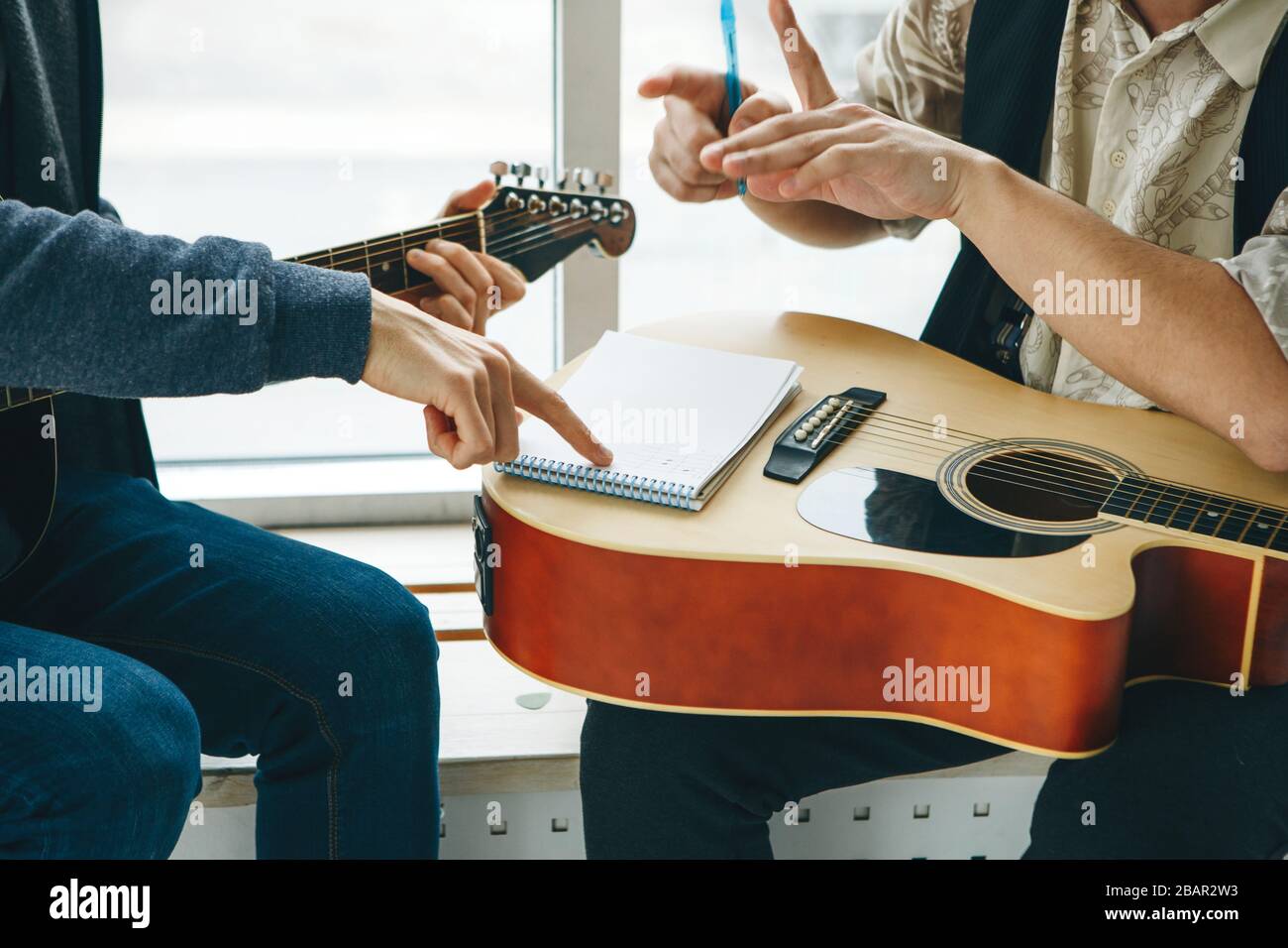 Learning to play the guitar. The teacher explains to the student the ...