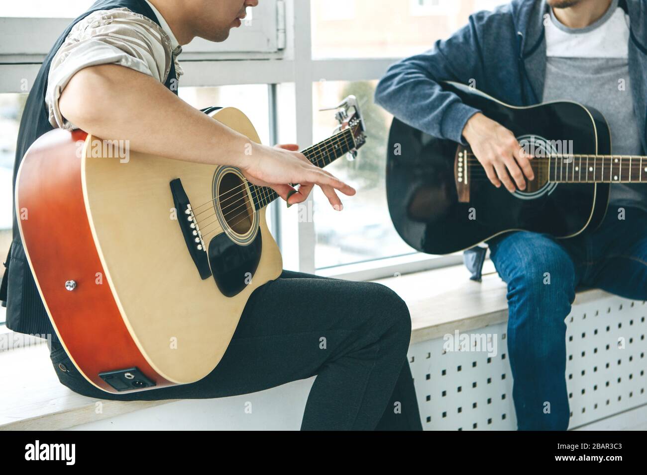 Learning to play the guitar. The teacher explains to the student the ...