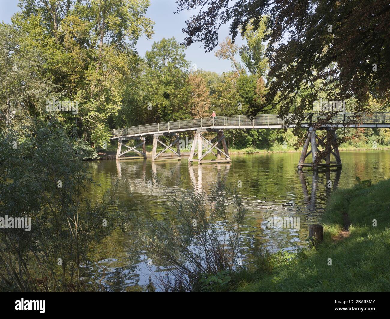 An idyllic summer day in Lübeck Germany, cyclist crossing the town moat ...