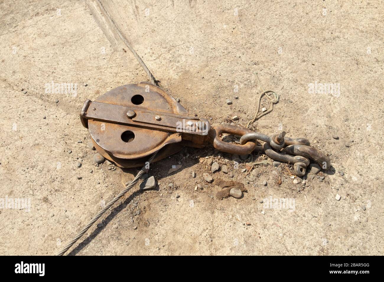 Old wire rope cable, block, pulley fixed to the the ground, used to ...