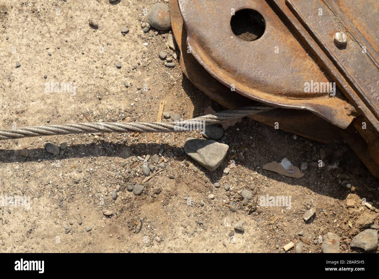 Old wire rope cable, block, pulley fixed to the the ground, used to ...