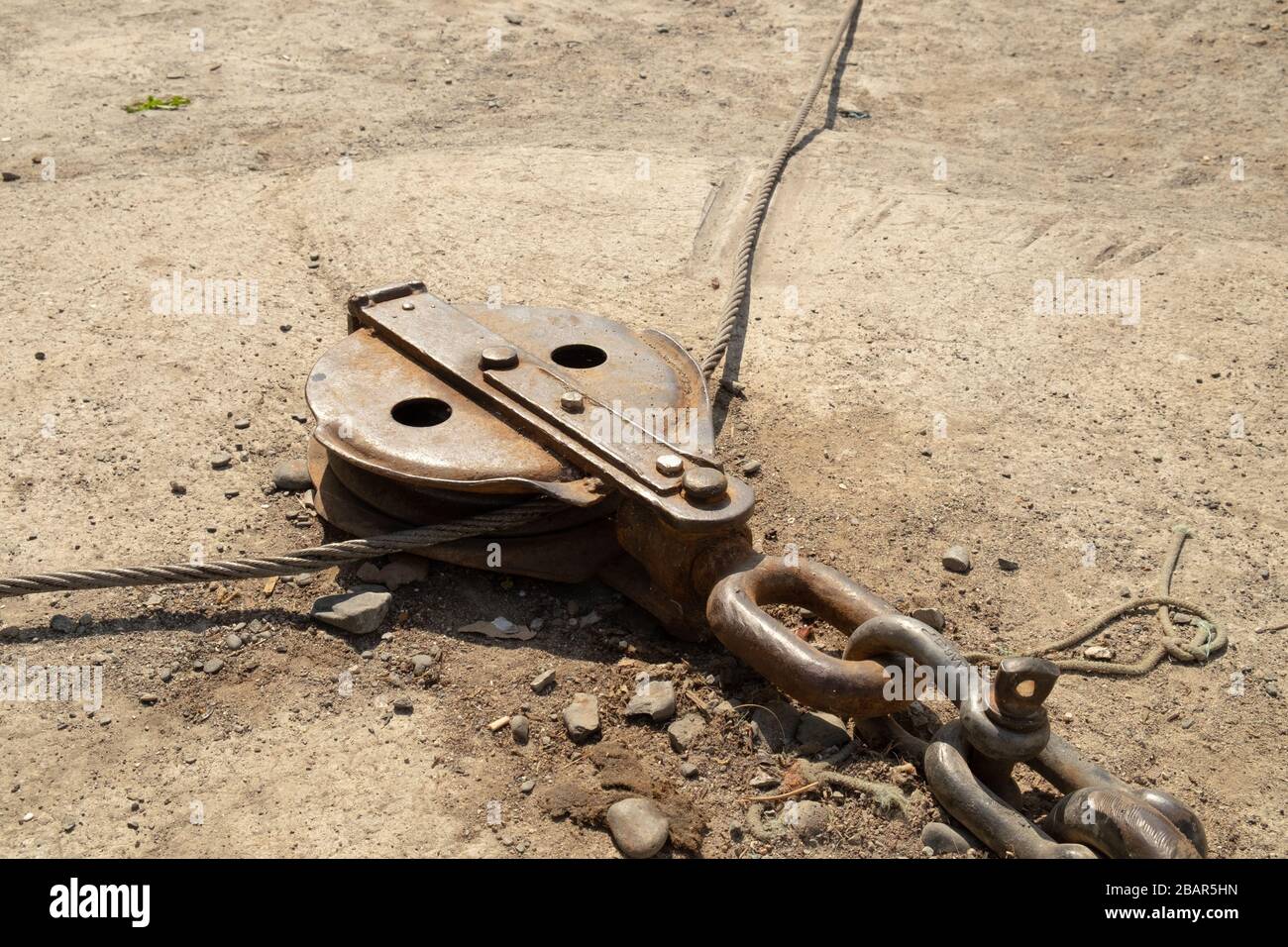 Old wire rope cable, block, pulley fixed to the the ground, used to ...