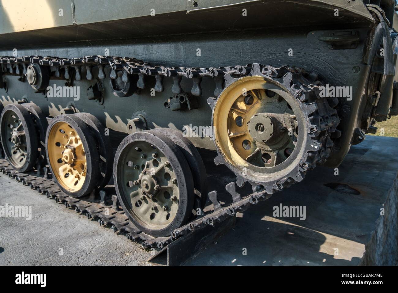 tracks and wheels of tank, armored vehicles on the street in green ...