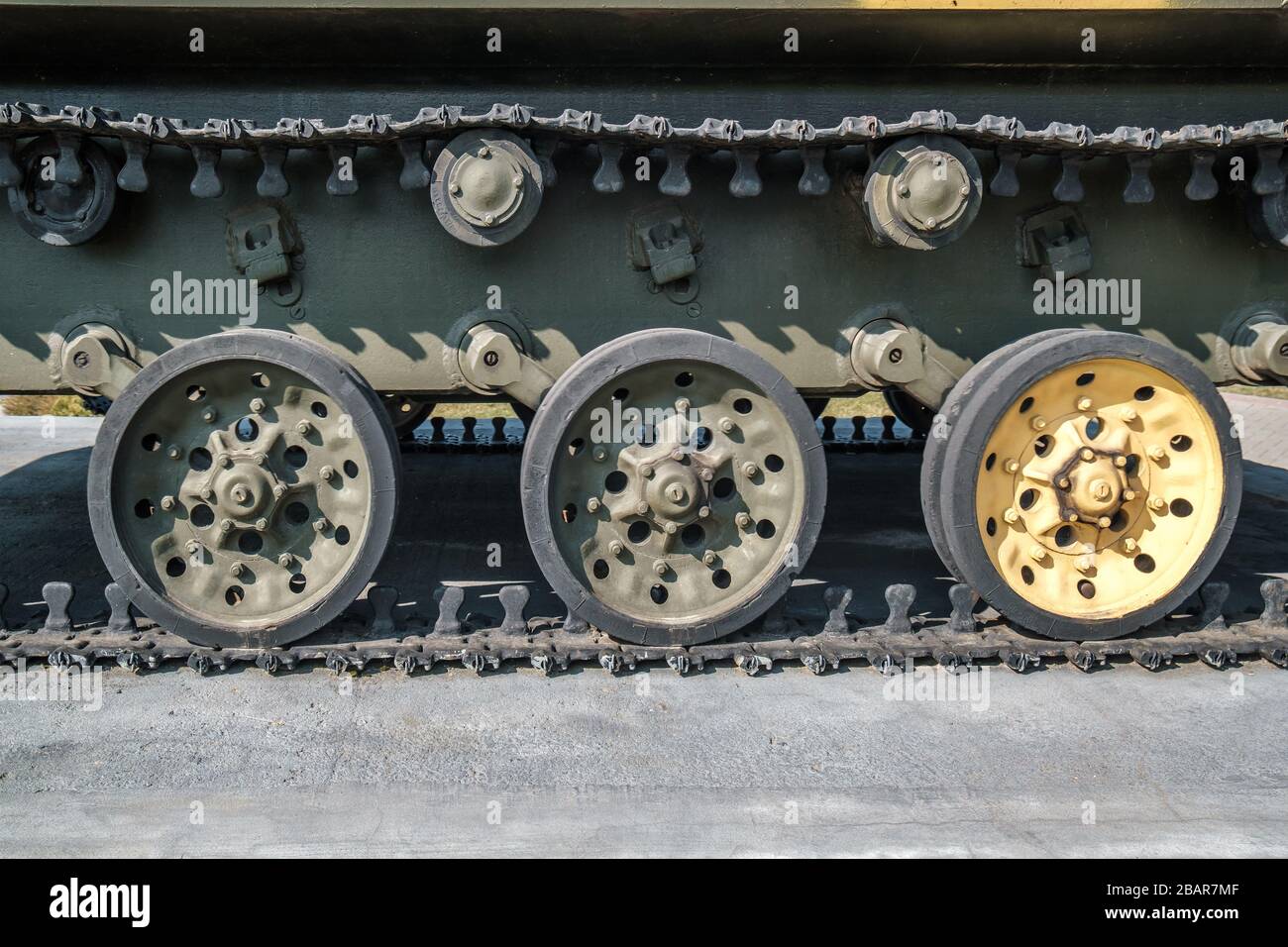 tracks and wheels of tank, armored vehicles on the street in green ...