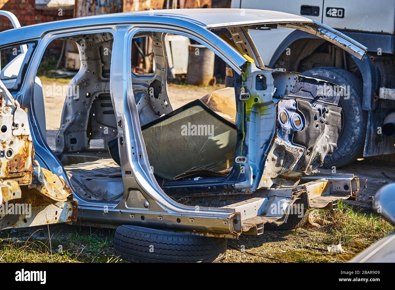 old gray car frame disassembled car with rusty parts on the street near ...