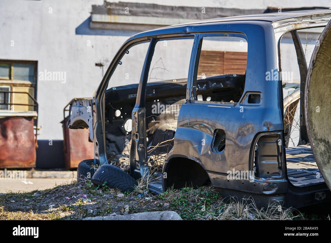 old gray car frame disassembled car with rusty parts on the street near ...