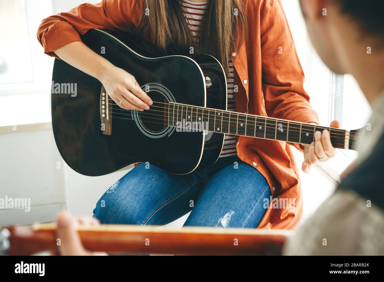 Learning to play the guitar. The teacher explains to the student the ...