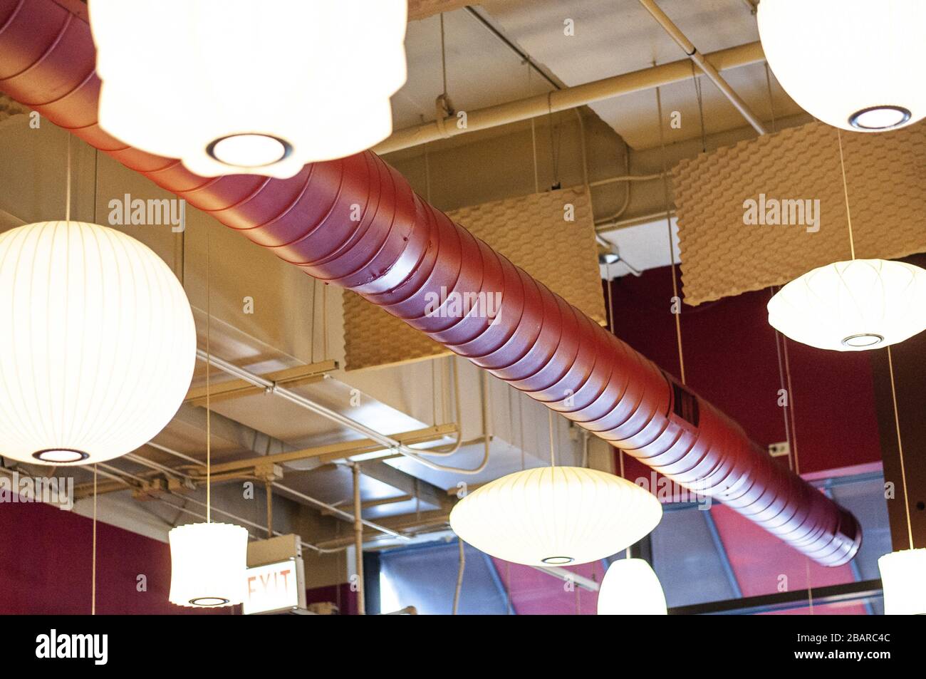 Low angle shot hanging lights and pipes in a restaurant Stock Photo - Alamy