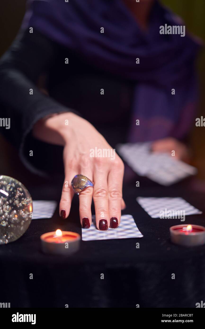 Close-up of woman fortuneteller's hand with fortune-telling cards at ...
