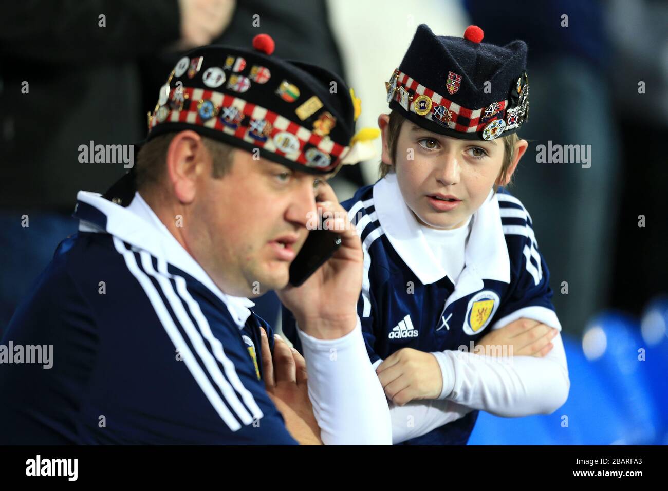 Scotland fans in the stands wearing hats with badges on Stock Photo - Alamy