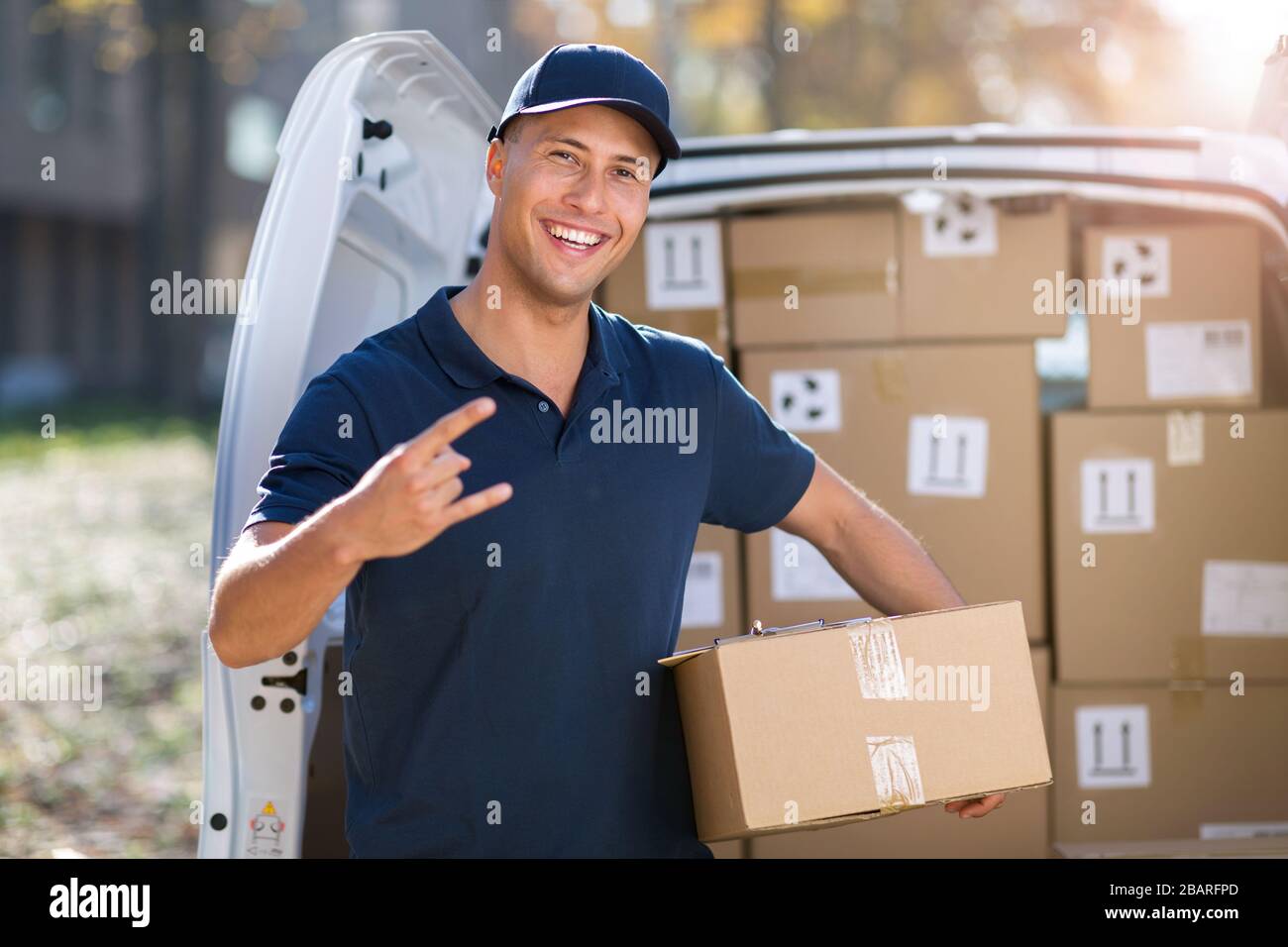 Smiling delivery man with his van Stock Photo - Alamy