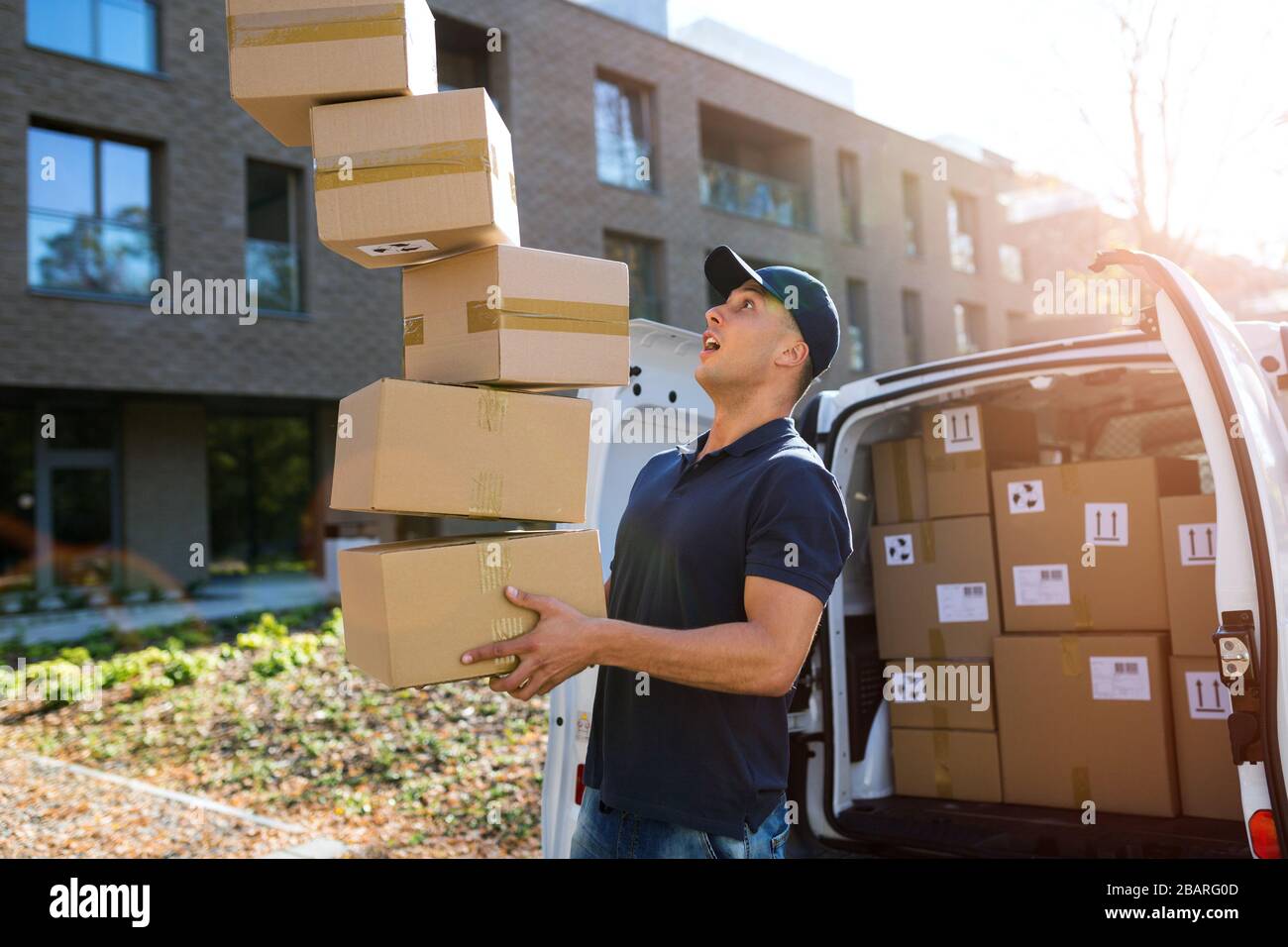 Smiling delivery man with his van Stock Photo - Alamy
