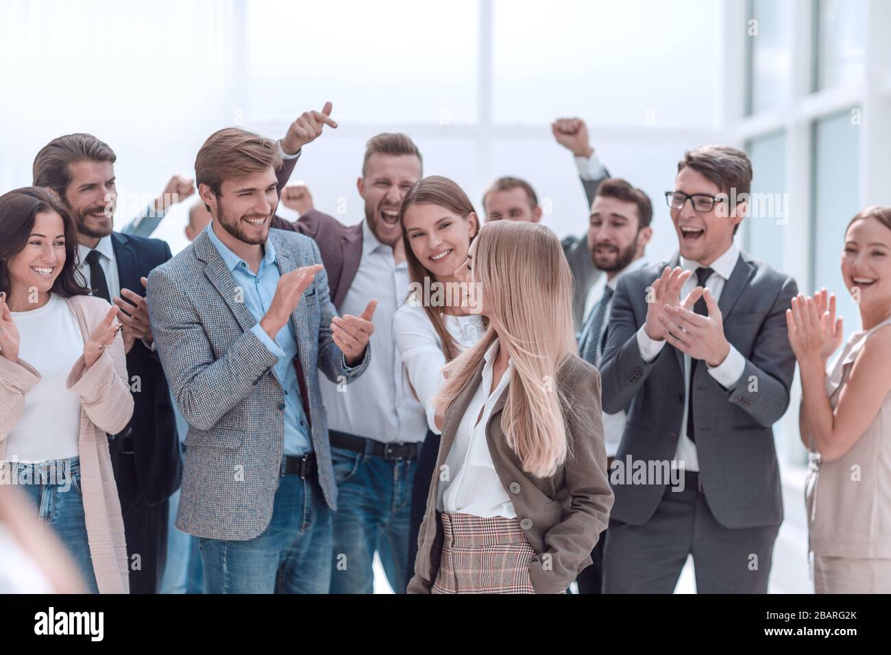 corporate group of employees applauding a young colleague Stock Photo ...