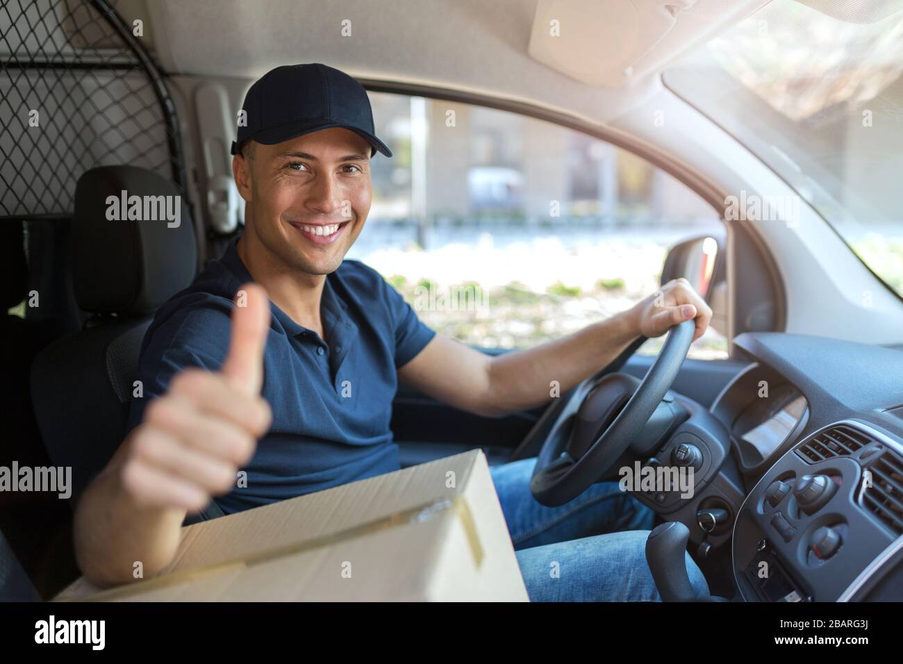 Smiling delivery man with his van Stock Photo - Alamy