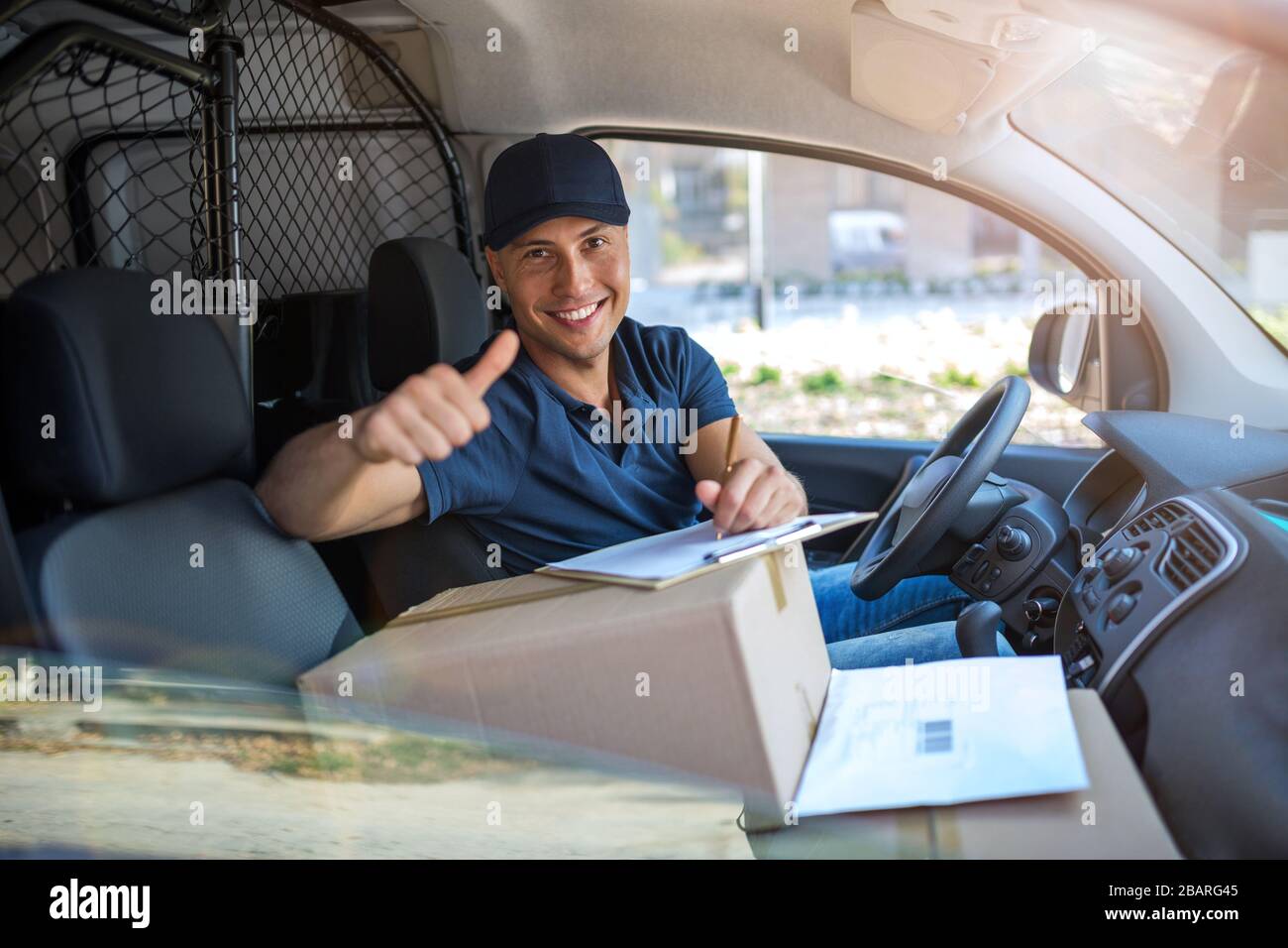 Smiling delivery man with his van Stock Photo - Alamy