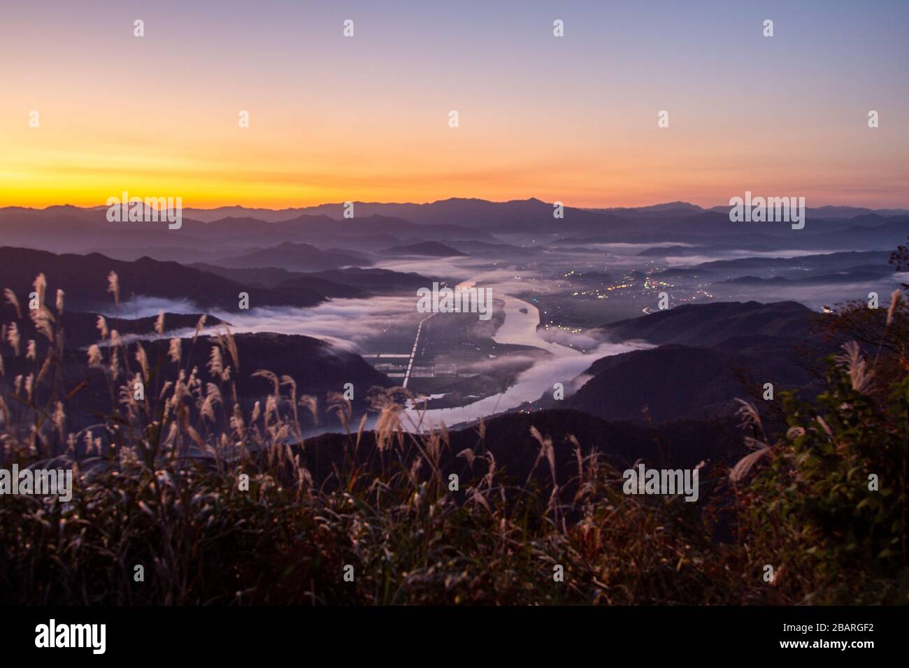 Misty morning sunrise over the bay and city of Toyooka (Toyooka-shi) is ...