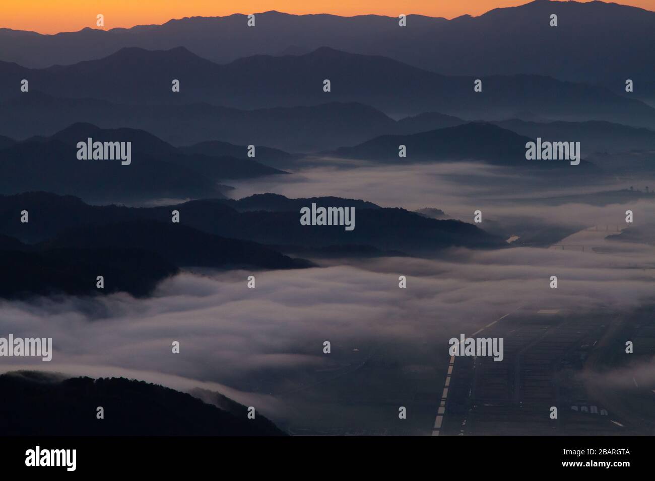 Misty morning sunrise over the bay and city of Toyooka (Toyooka-shi) is ...