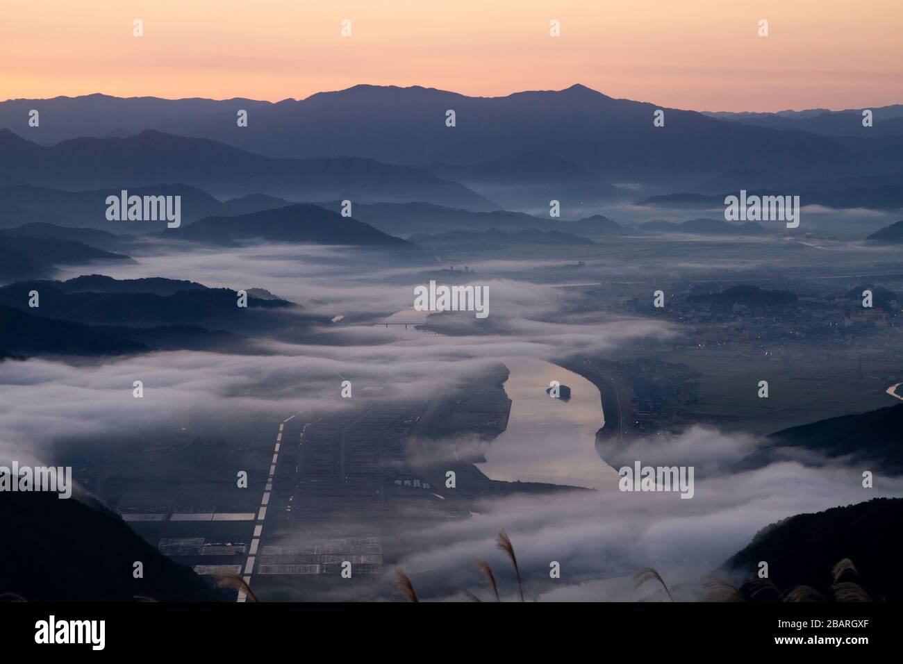 Misty morning sunrise over the bay and city of Toyooka (Toyooka-shi) is ...