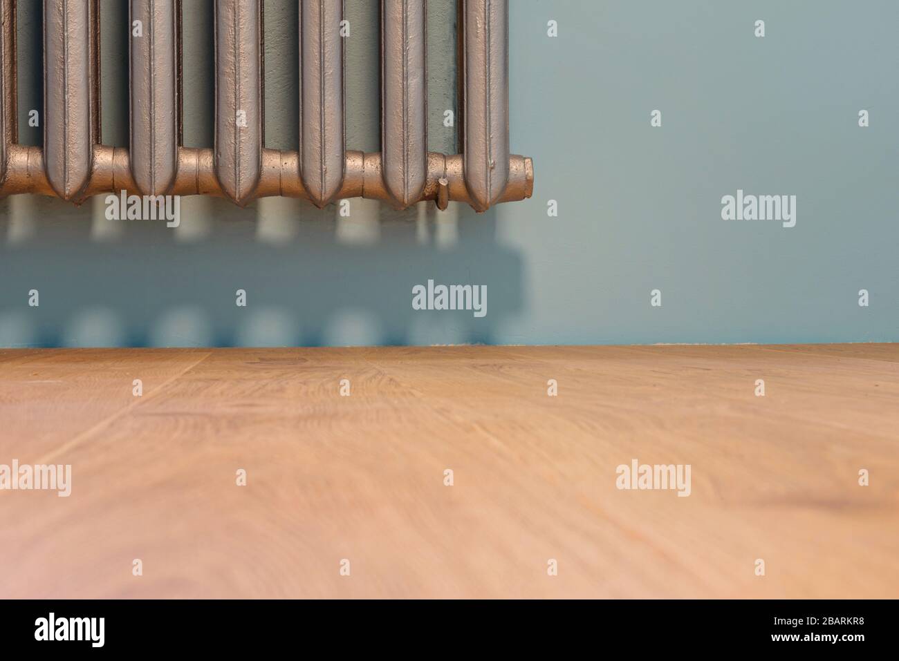 Natural wooden parquet and cast iron radiator Stock Photo - Alamy