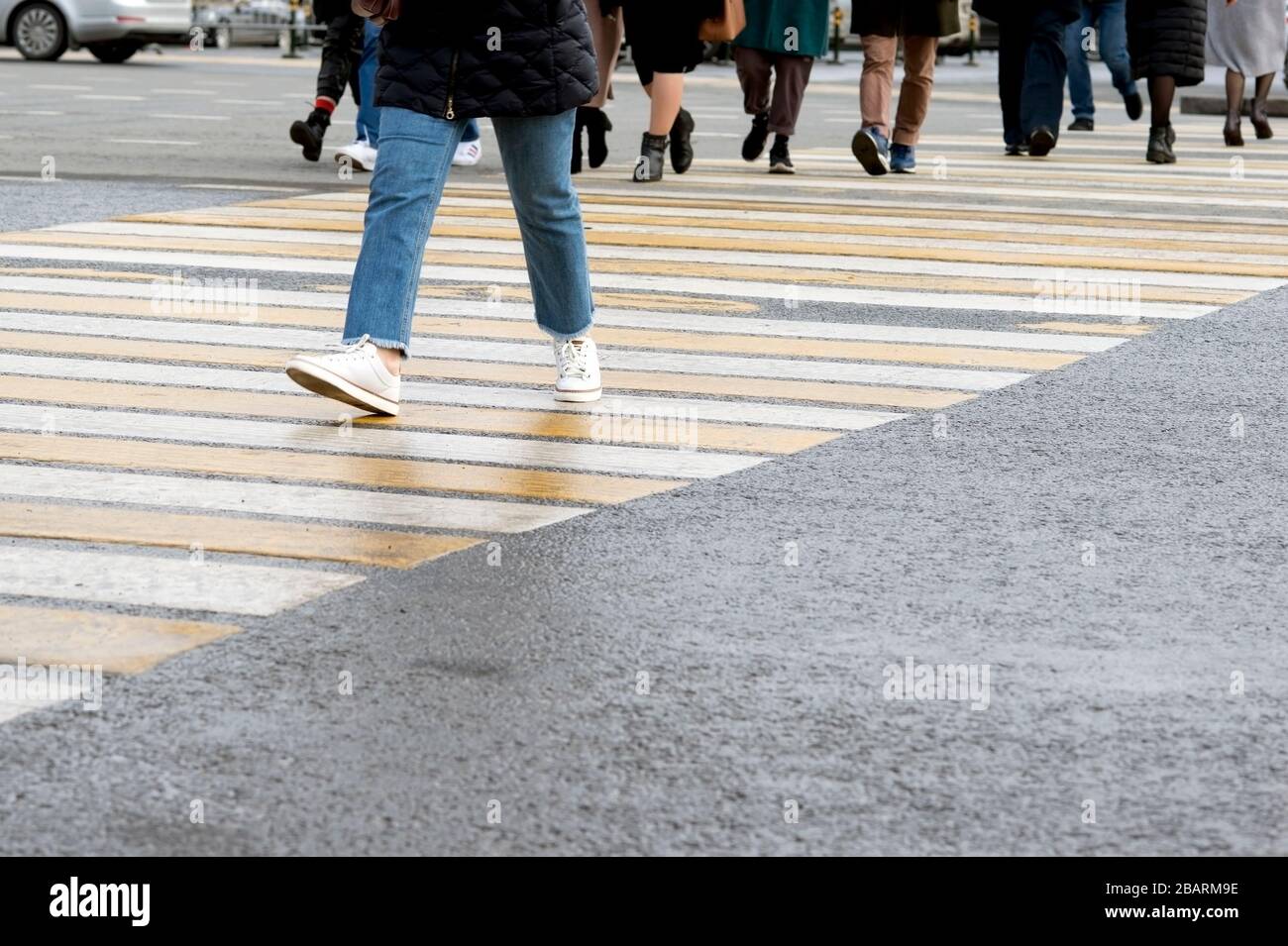 People cross the road at the pedestrian crosswalk at the intersection ...