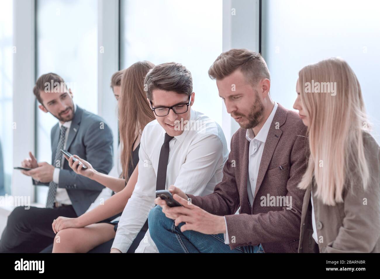 young employees using their smartphones to view the news online Stock ...