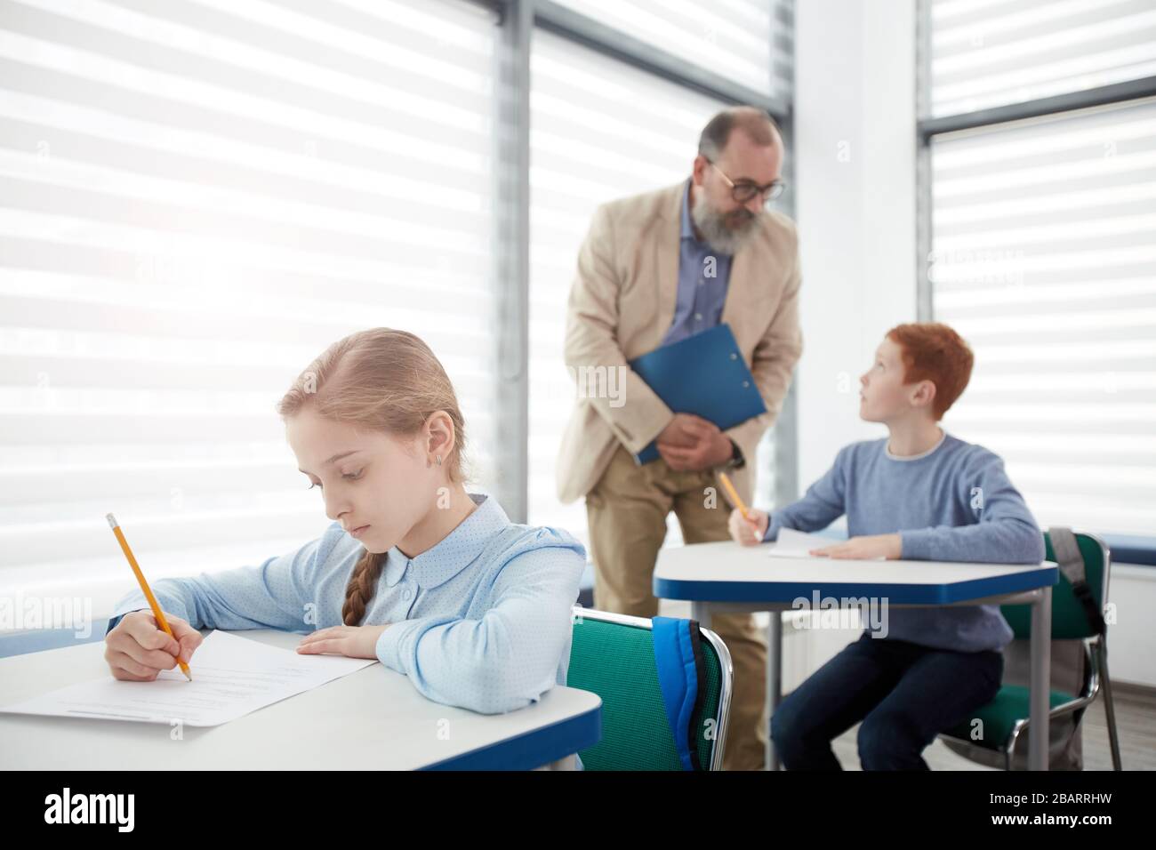 Student writing exam teacher watching hi-res stock photography and ...