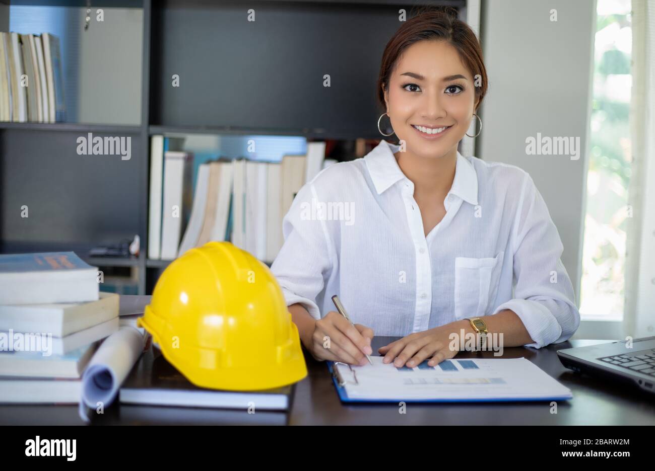 Beautiful Asian engineering women checking document and using notebook ...