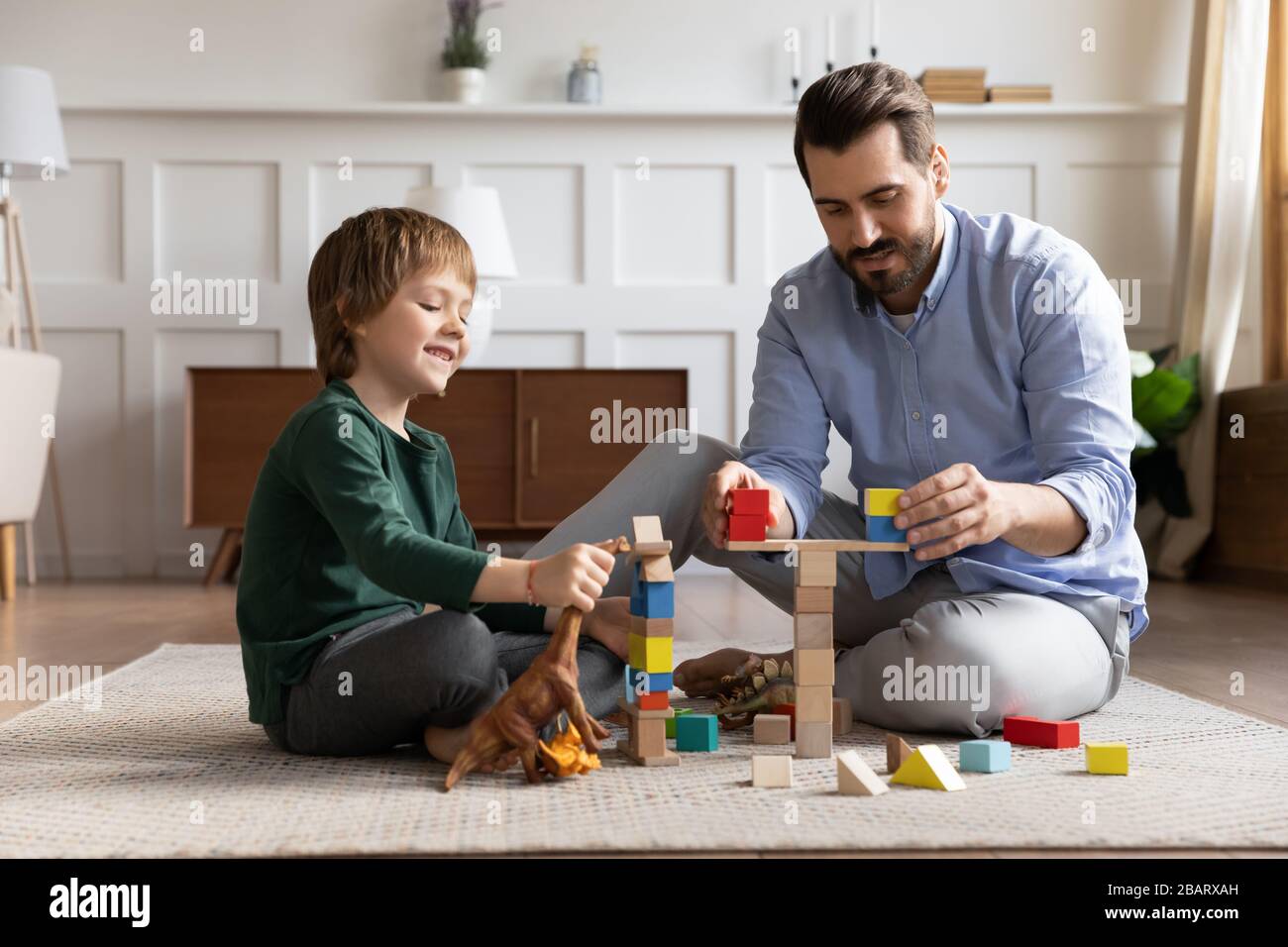 Smiling little child boy enjoying constructing building with father ...