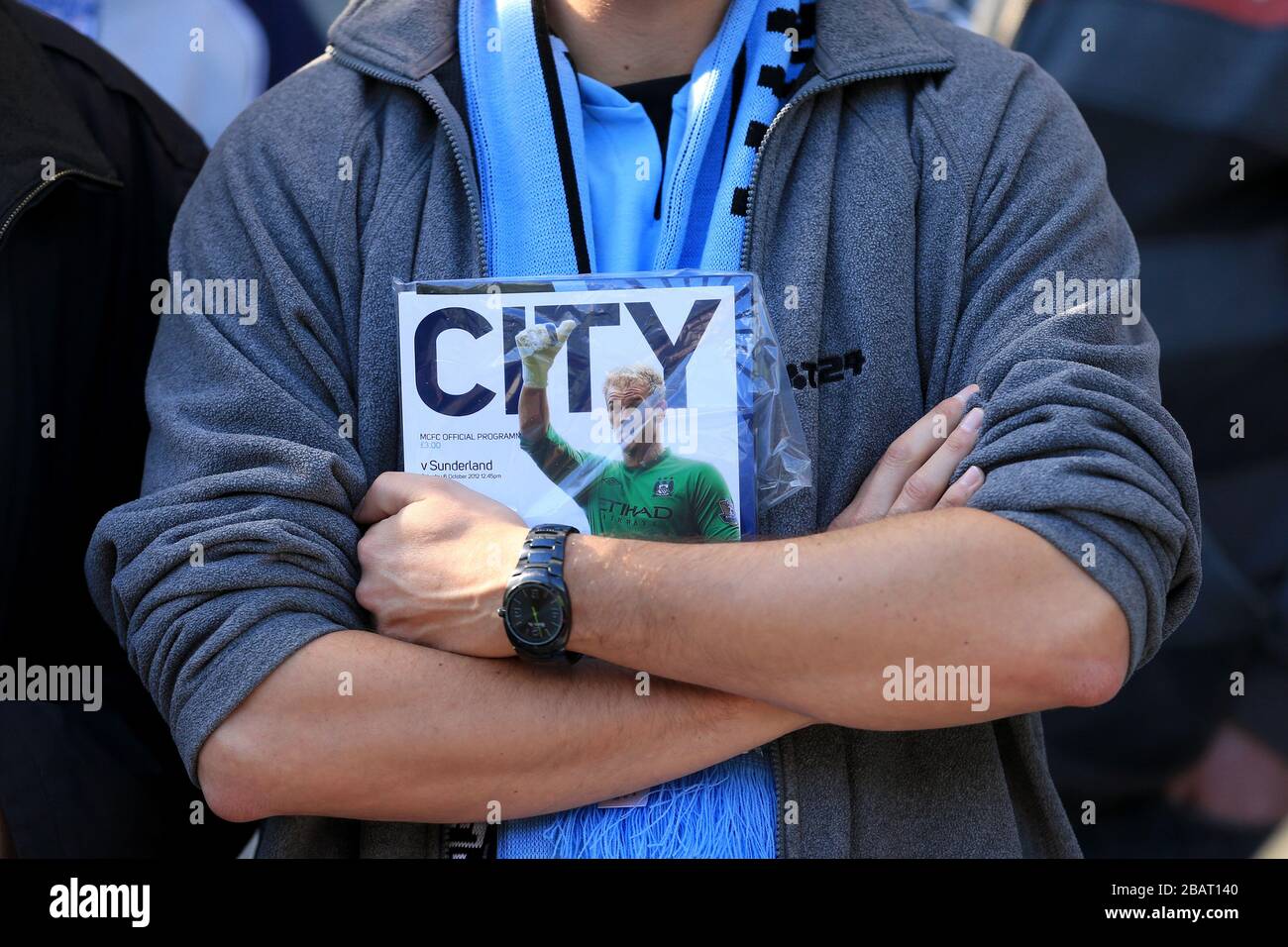 A Manchester City fan holds the match day programme before kick off ...