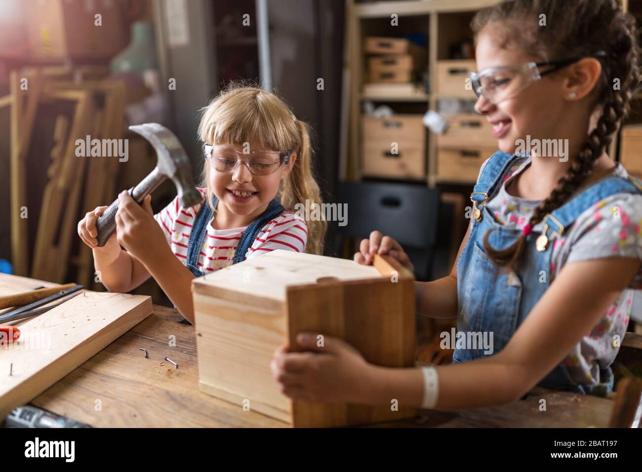 Two young girls doing woodwork in a workshop Stock Photo - Alamy