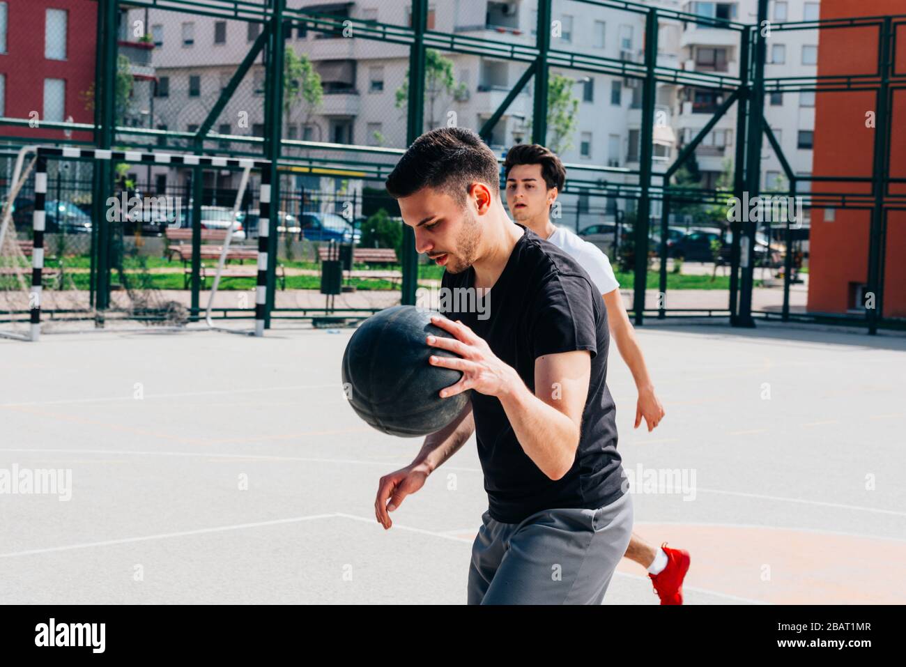 Fit male basketball player early in the morning on a sunny day at the ...