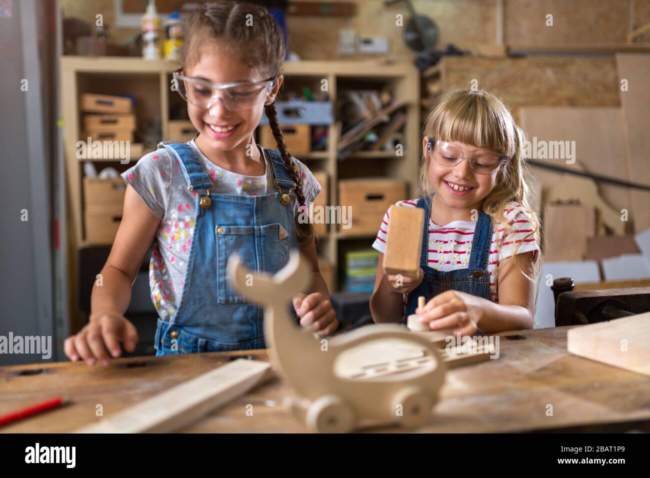 Two young girls doing woodwork in a workshop Stock Photo - Alamy