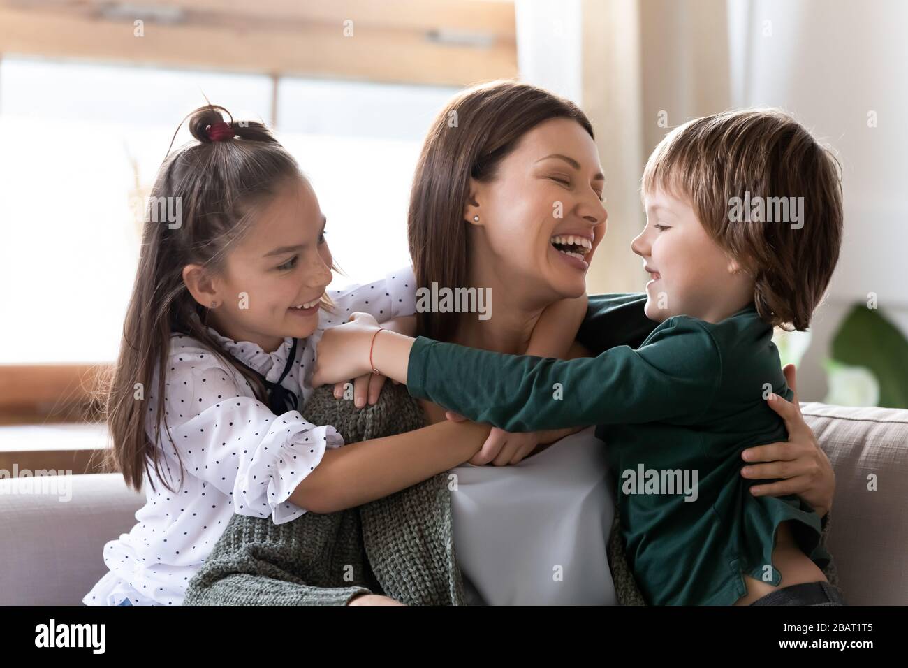 Overjoyed young mother communicating joking with little children Stock ...