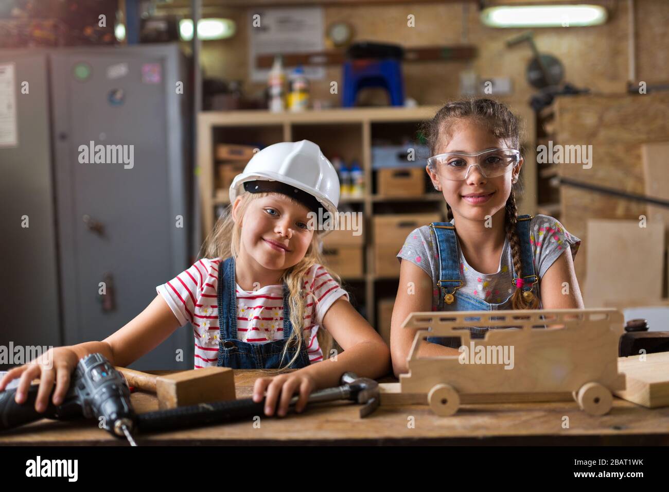 Two young girls doing woodwork in a workshop Stock Photo - Alamy