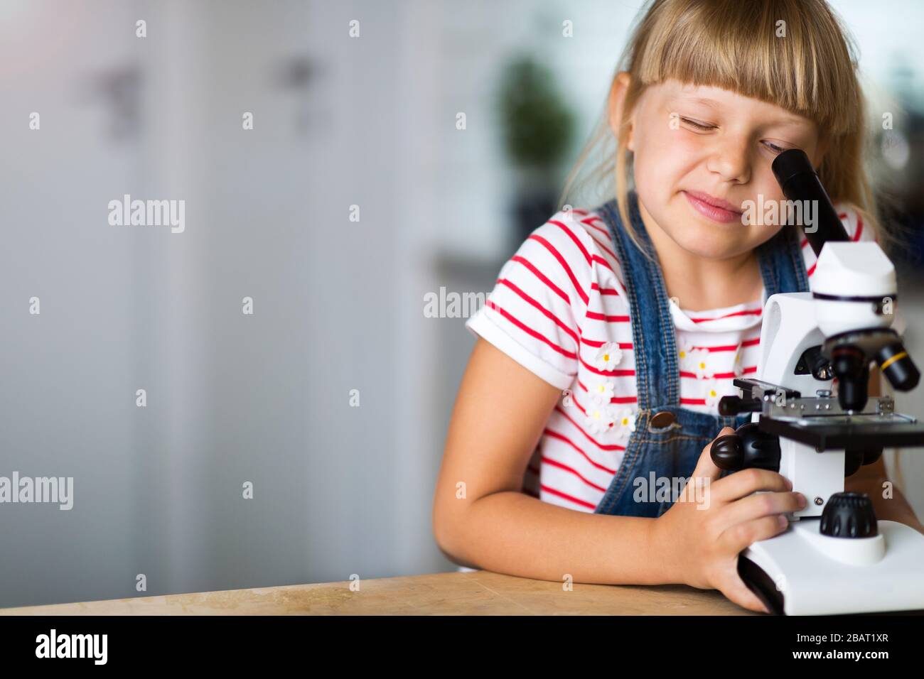 Young girl looking through microscope Stock Photo - Alamy