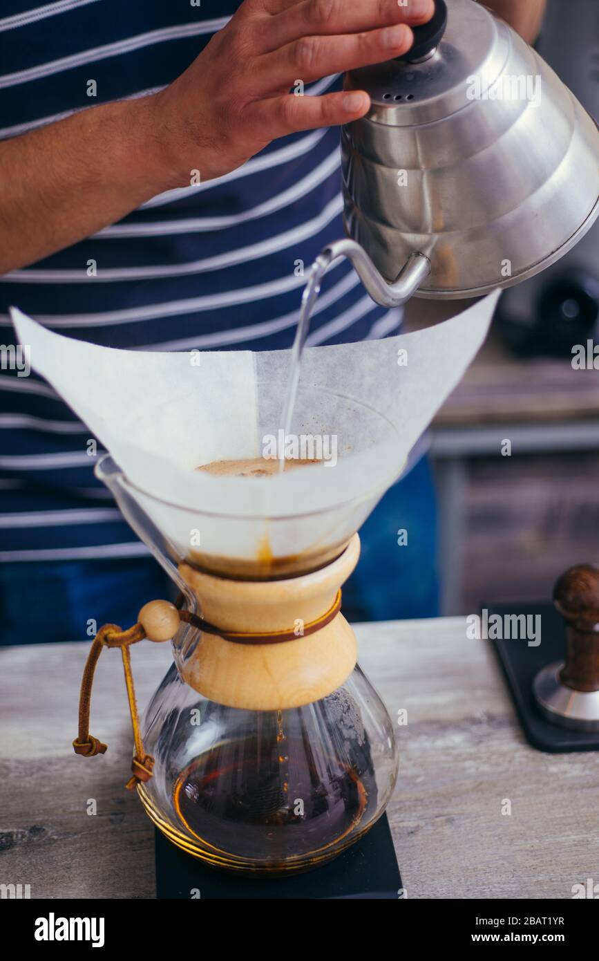 Male barista using a coffee maker to make a nice cup of coffee. Cafe ...