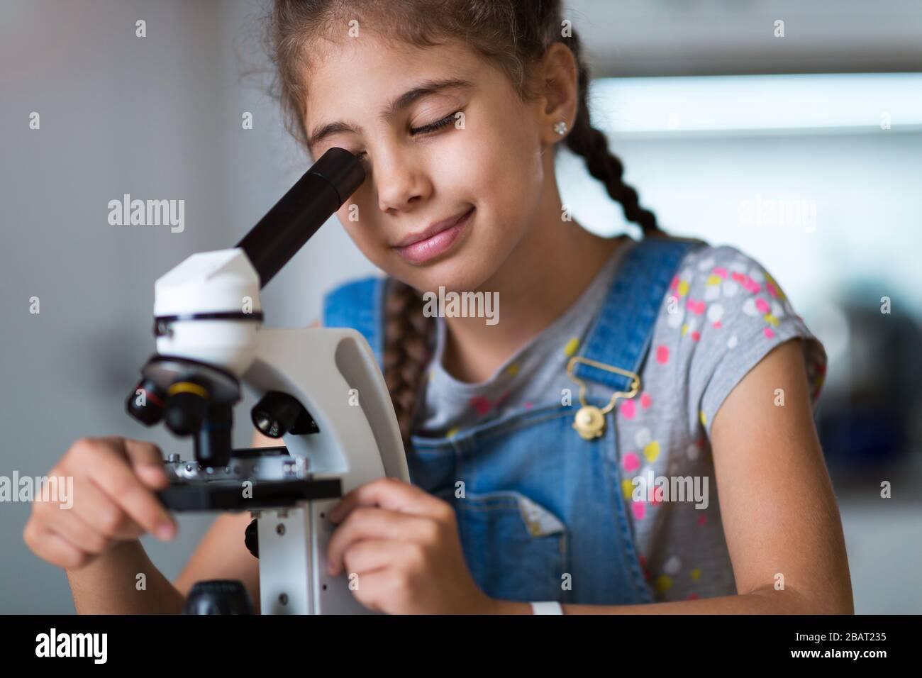 Young girl looking through microscope Stock Photo - Alamy