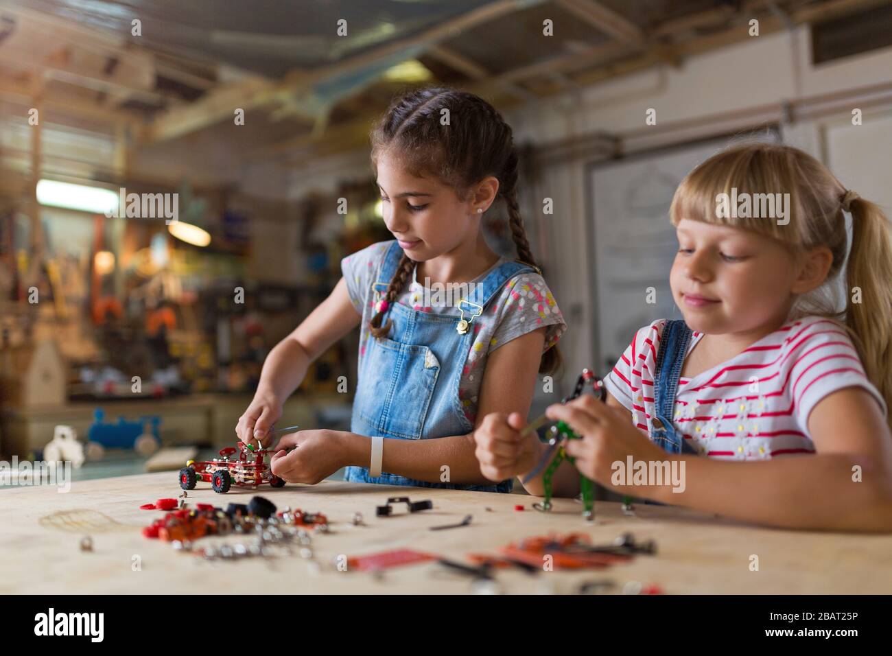 Small girls cooperating while making a robot Stock Photo - Alamy