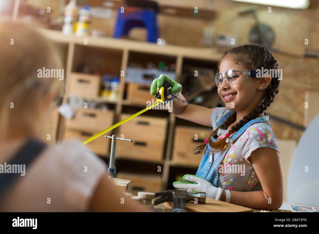 Two young girls doing woodwork in a workshop Stock Photo - Alamy