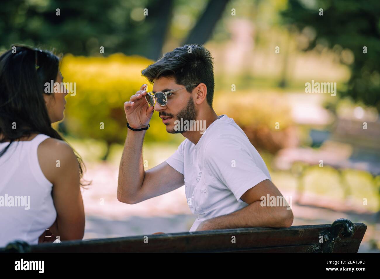 Couple talking seriously outdoors in a park with a green background ...