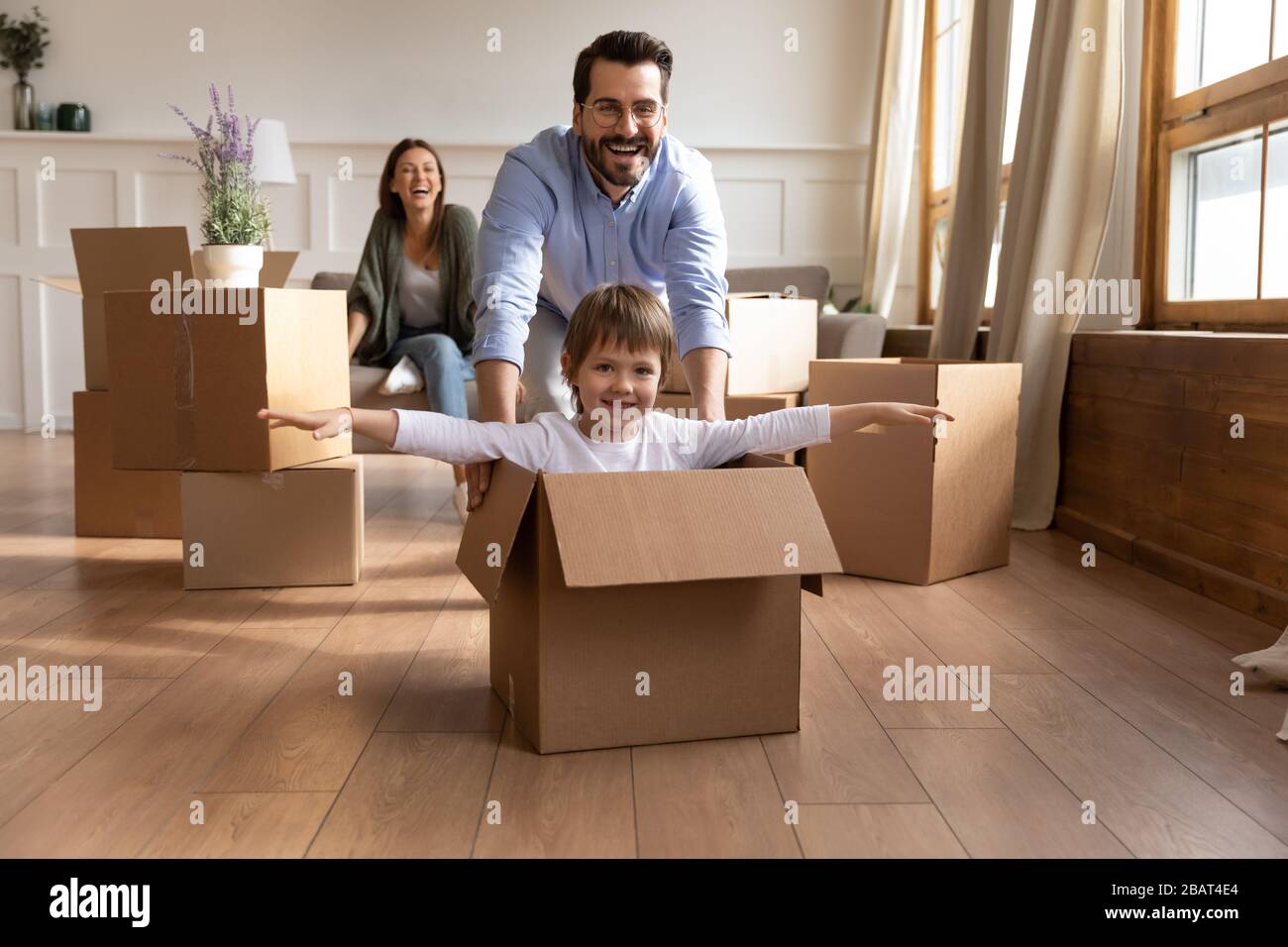 Happy young father pushing carton box with small kid son Stock Photo ...