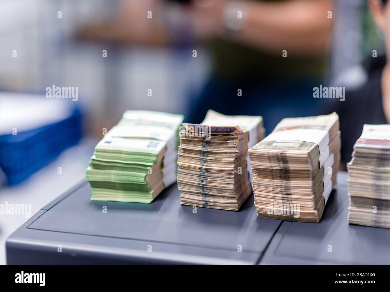 Bundles of different types of cash divided with currency bands and ...